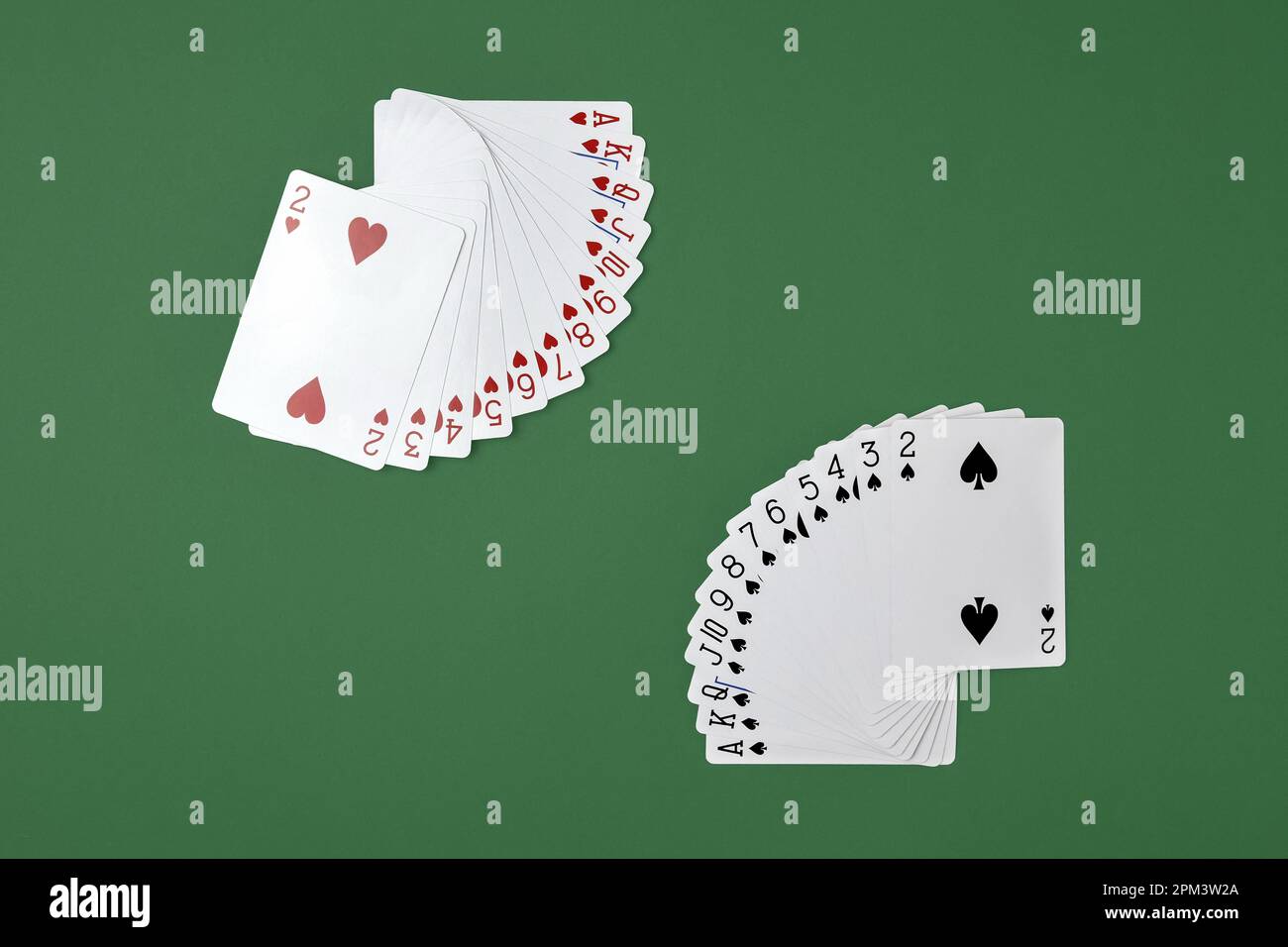 Deck of playing cards on green background. Cards of hearts and spades ...