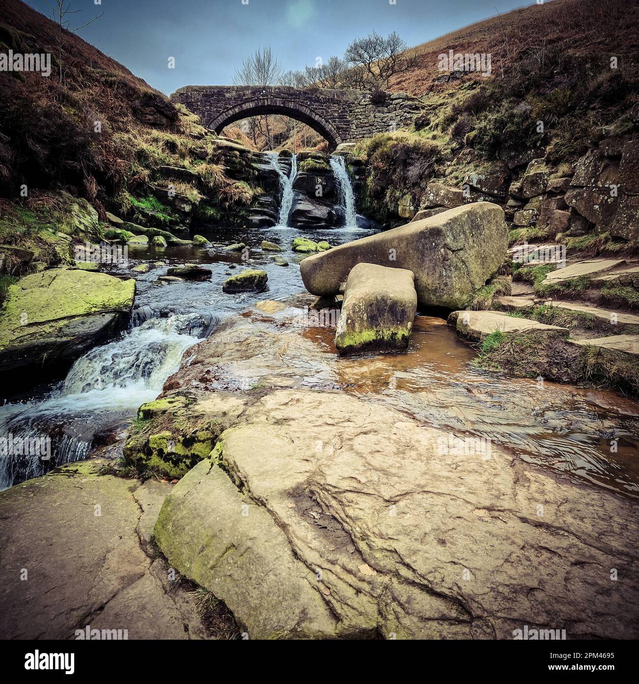 Three Shire Heads, where water cascades over mossy rocks and a ...