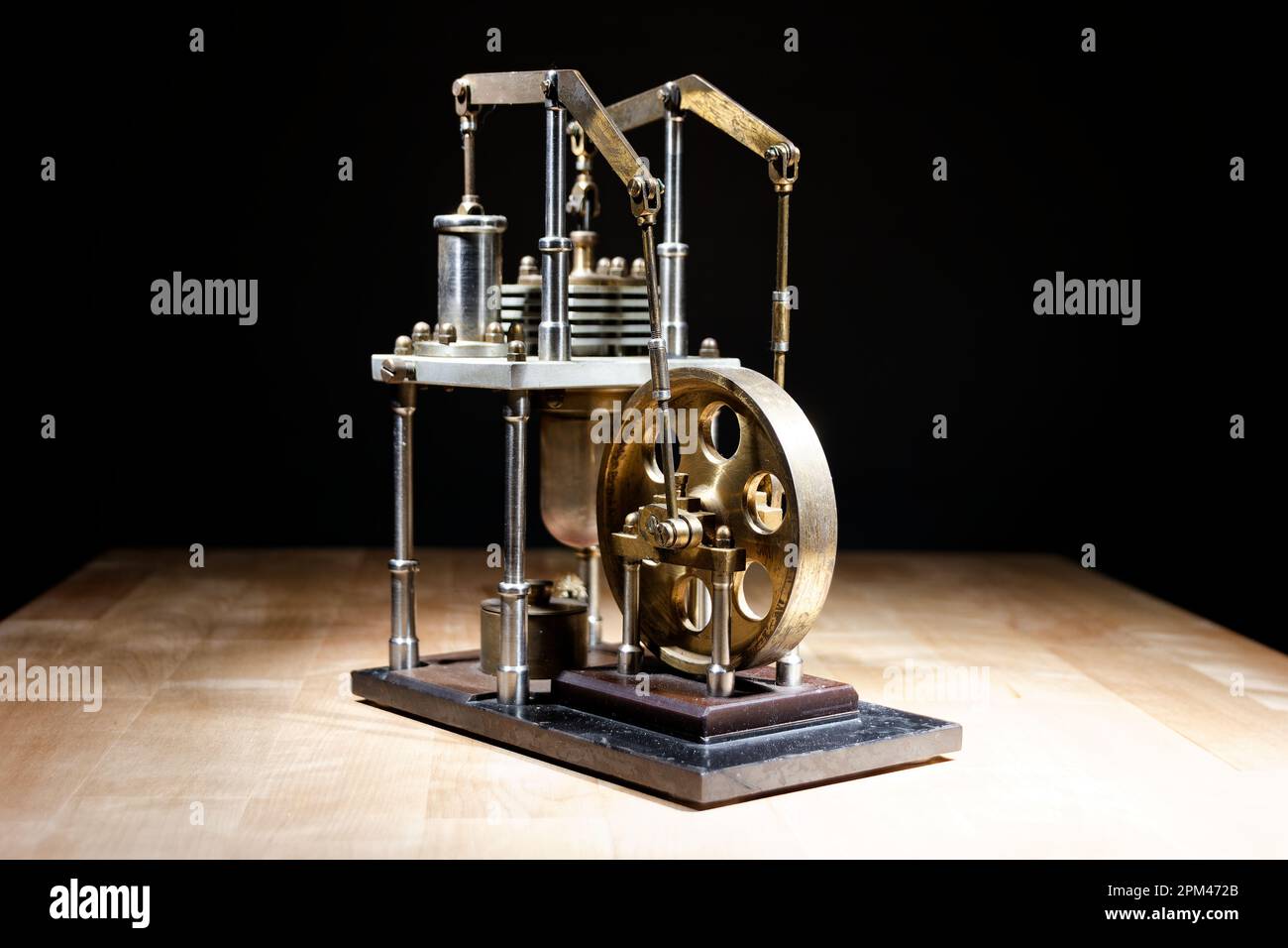 closeup of a stirling engine construction with wooden table and black ...