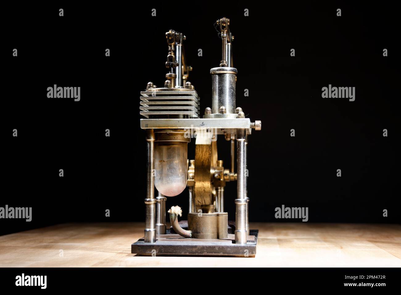 closeup of a stirling engine construction with wooden table and black ...
