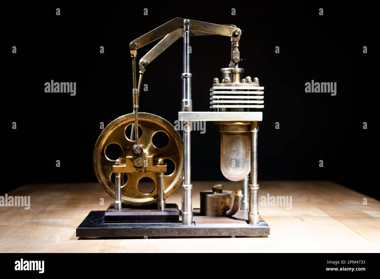 closeup of a stirling engine construction with wooden table and black ...
