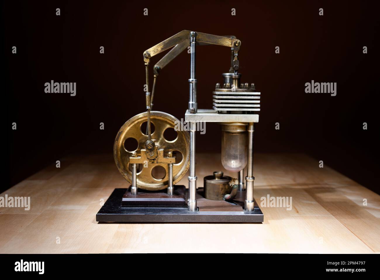 closeup of a stirling engine construction with wooden table and black ...