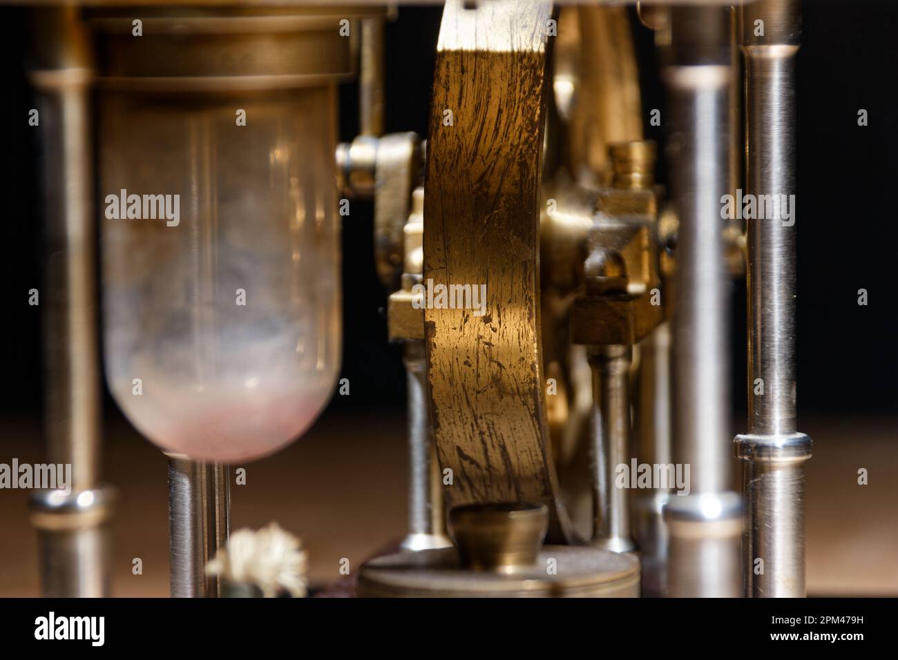 closeup of a stirling engine construction with wooden table and black ...