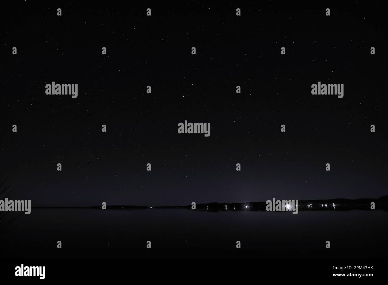 A tranquil night time scene with a still body of water reflecting the ...