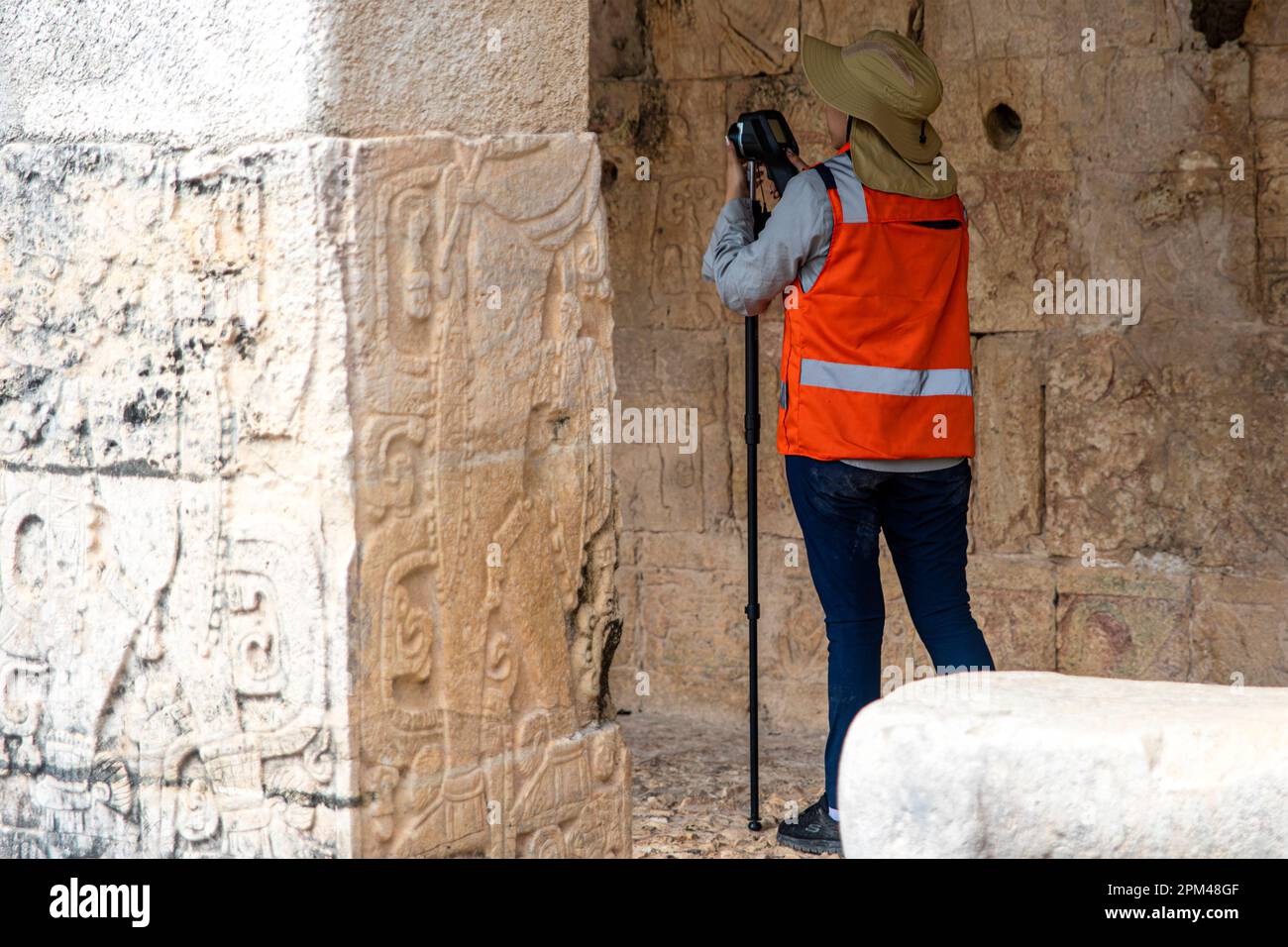 An archaeologist with instruments working in one of the ancient Mayan ...