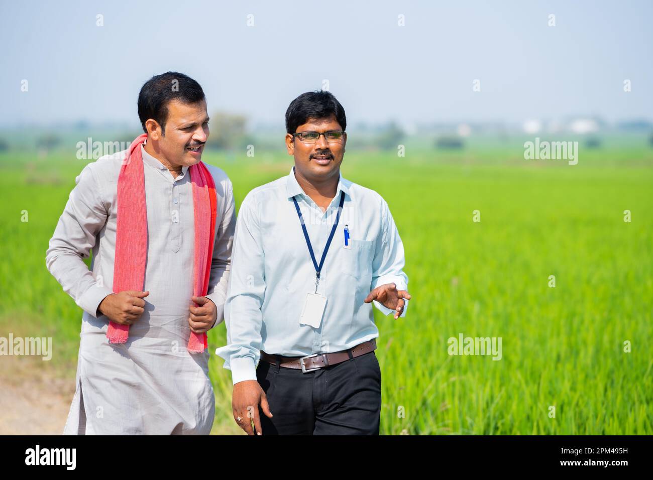 Banking officer with Village farmer discussing by looking around ...