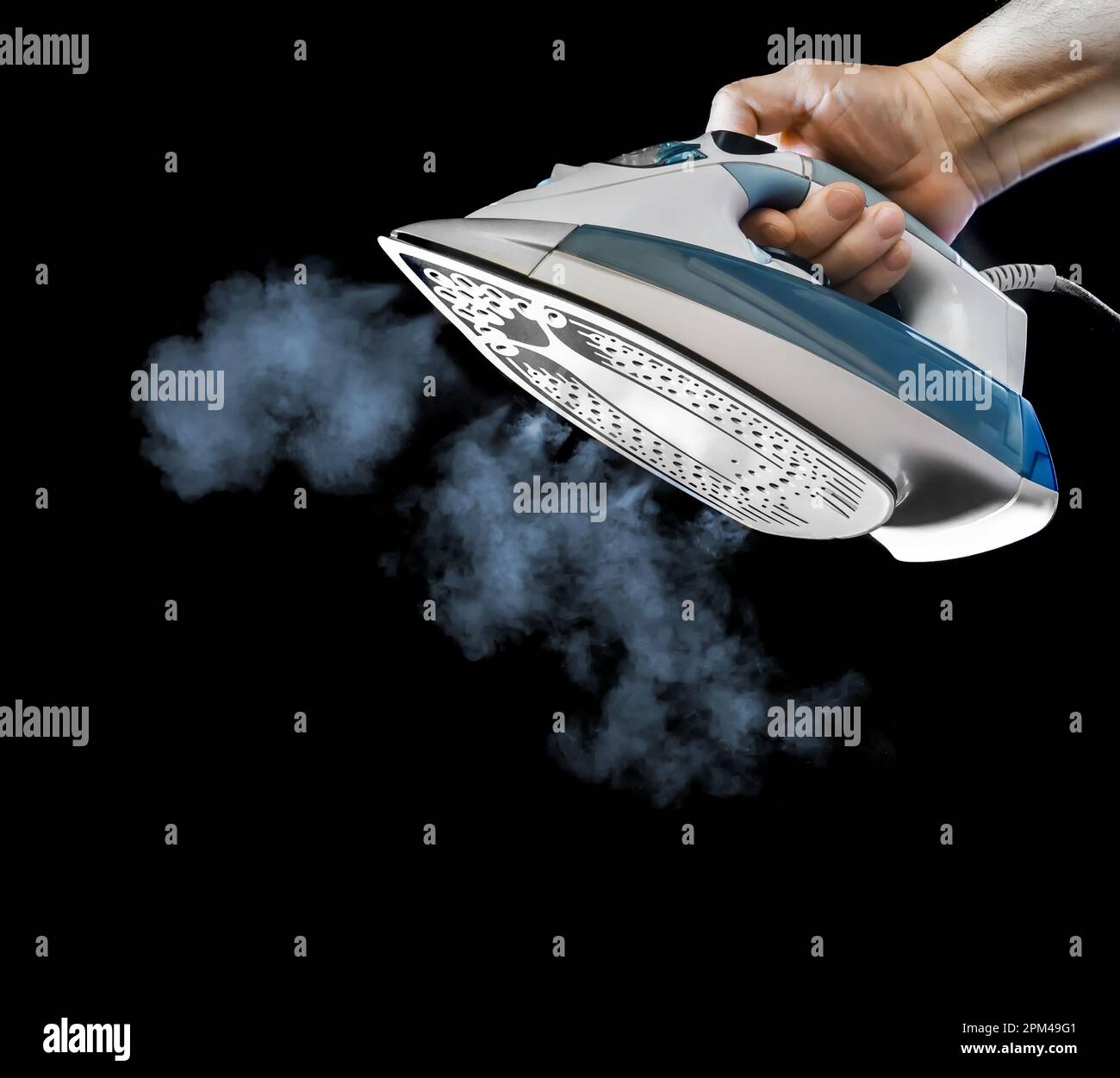 Hand holds an Iron with steam, isolated on black background Stock Photo ...