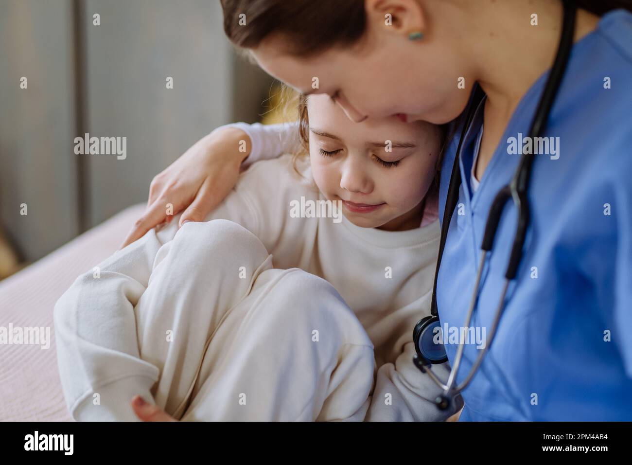 Young doctor hugging little girl in hospital room Stock Photo - Alamy