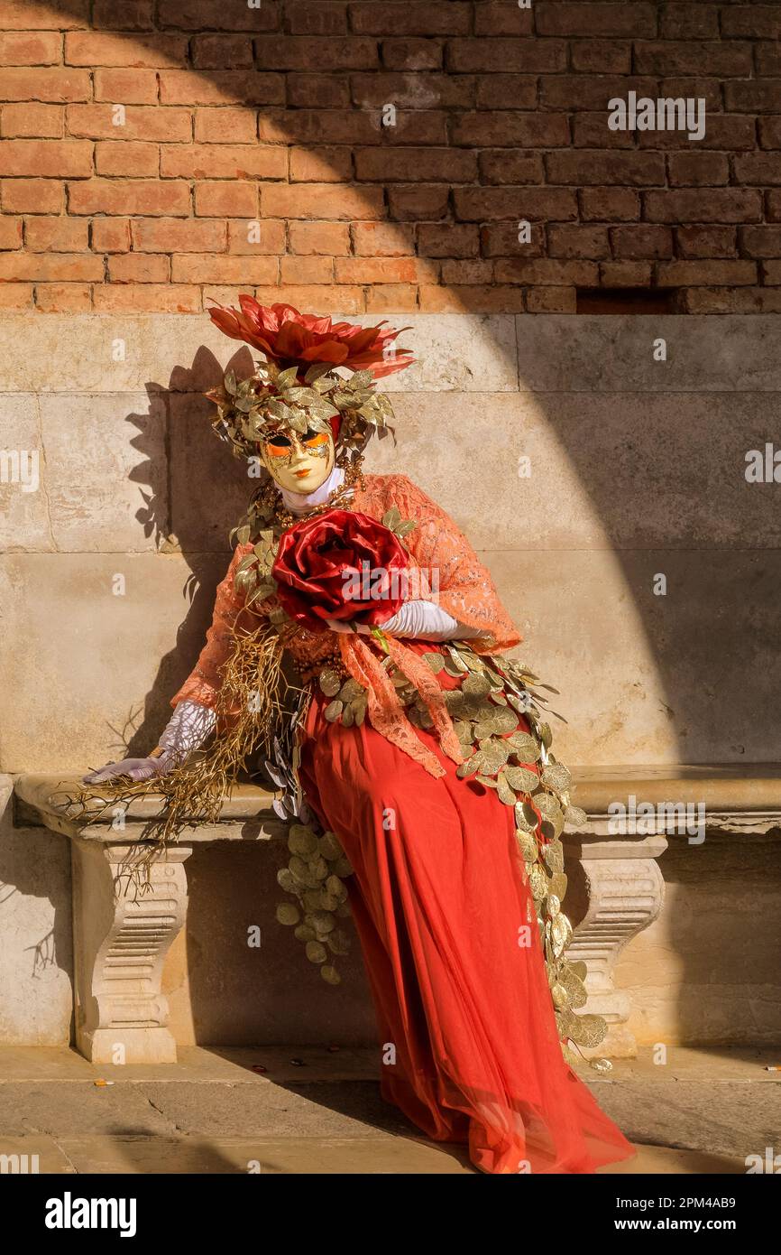 Venice carnival, costumed woman, carnival participant in red dress ...