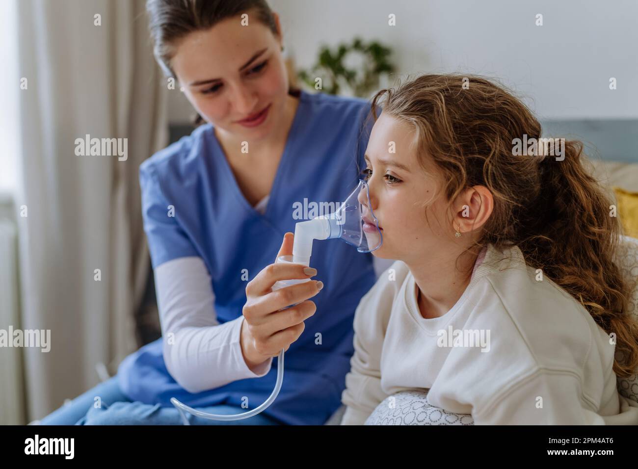 Little girl with inhaler in hospital room, nurse chcecking her Stock ...
