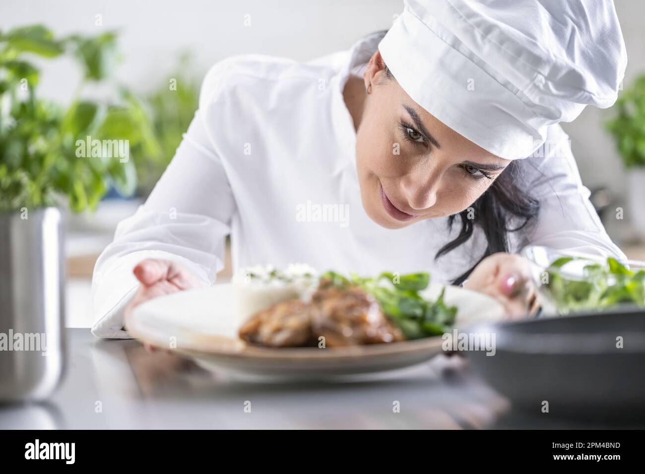 An experienced chef checks the finished food before the waiter takes it ...