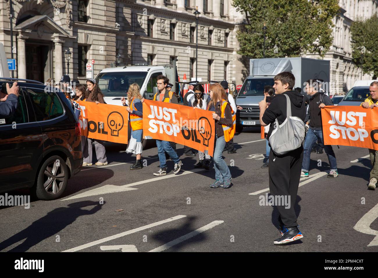 ‘Just Stop Oil’ activists try to hold a banner in front of the traffic ...