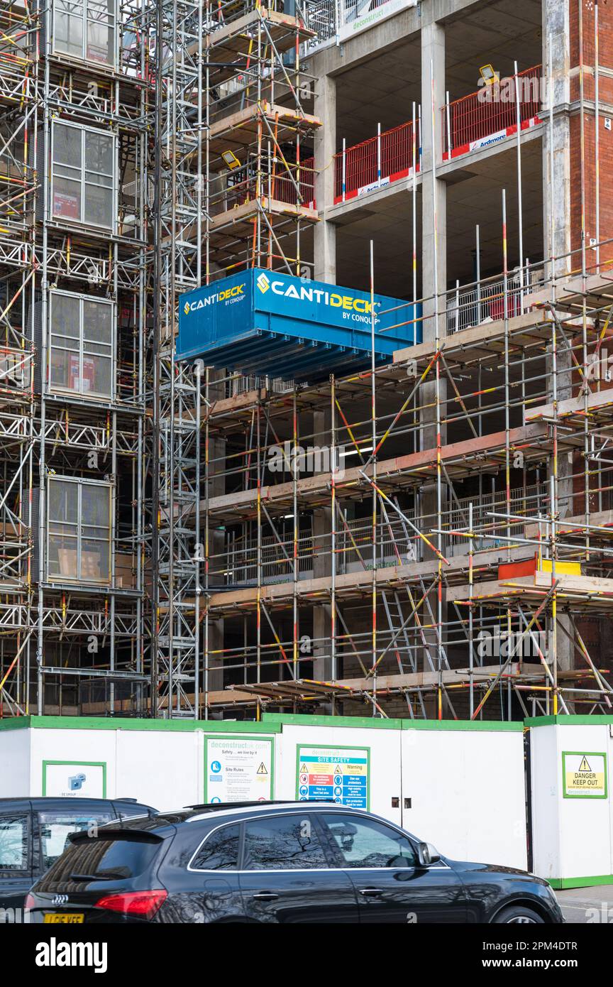 Construction site with scaffolding, goods and personnel hoist and ...