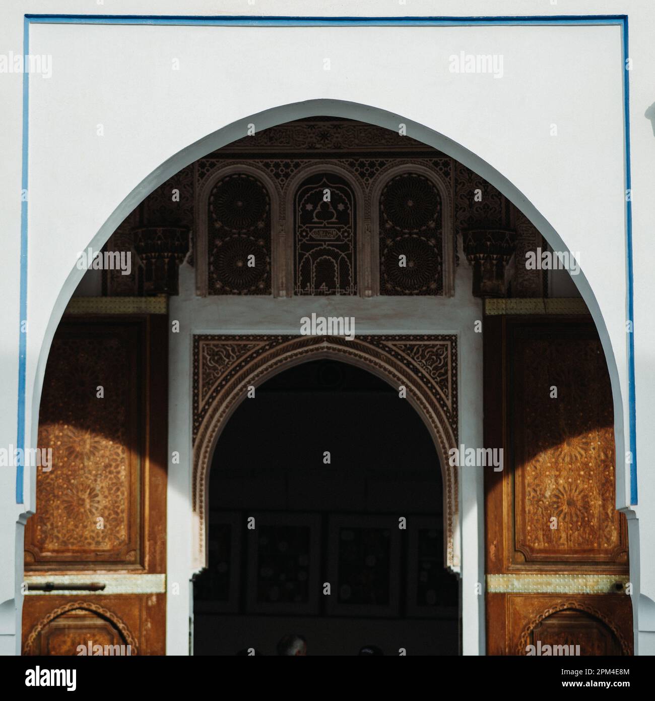 An exterior shot of a building featuring an impressive arched doorway ...