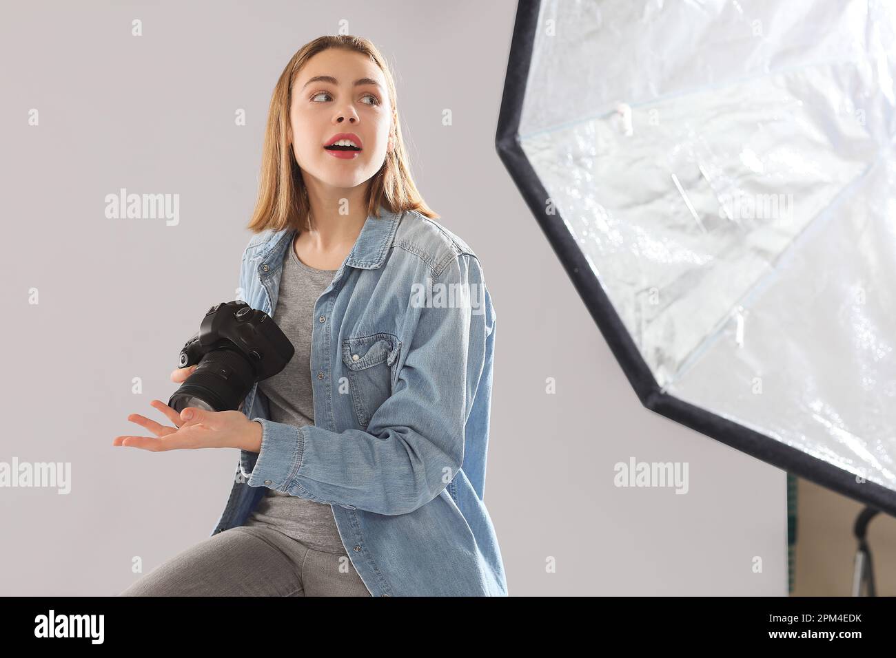 Female photographer with professional camera sitting in studio Stock ...