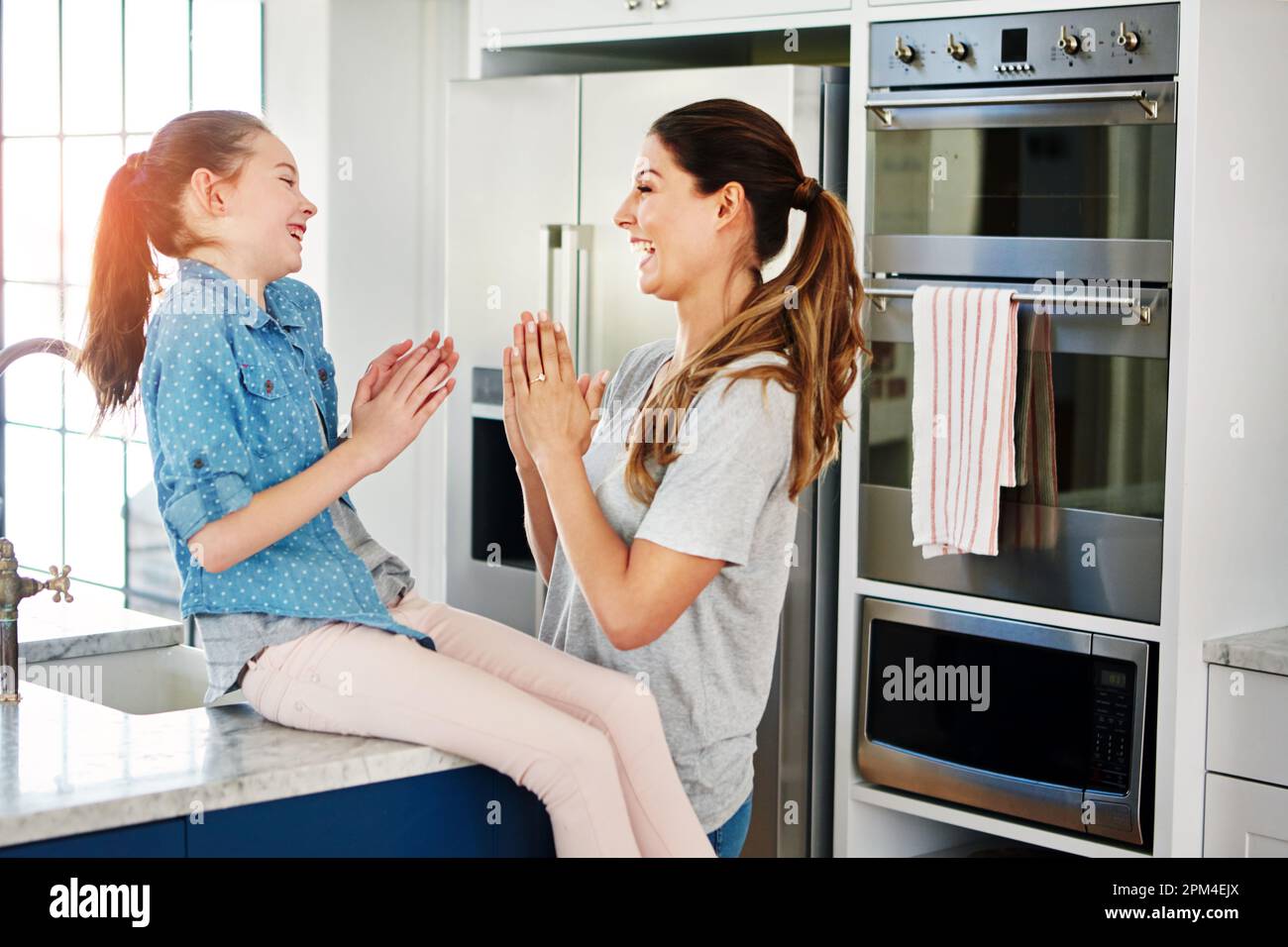 Passing down fun clapping games from generation to generation. a happy mother and daughter ...
