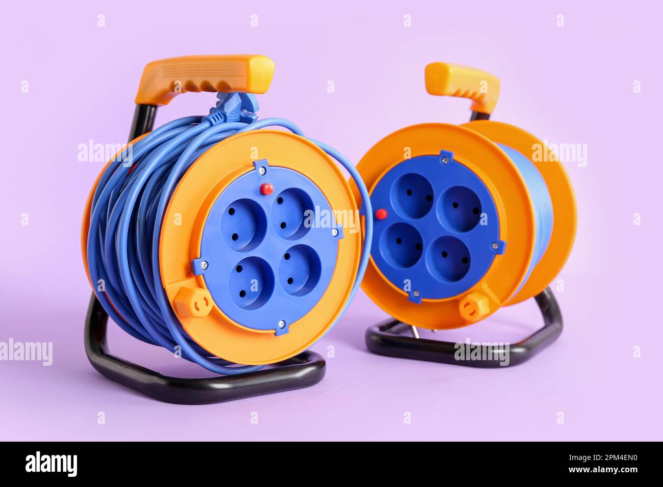 Extension electric cable reels on lilac background Stock Photo - Alamy