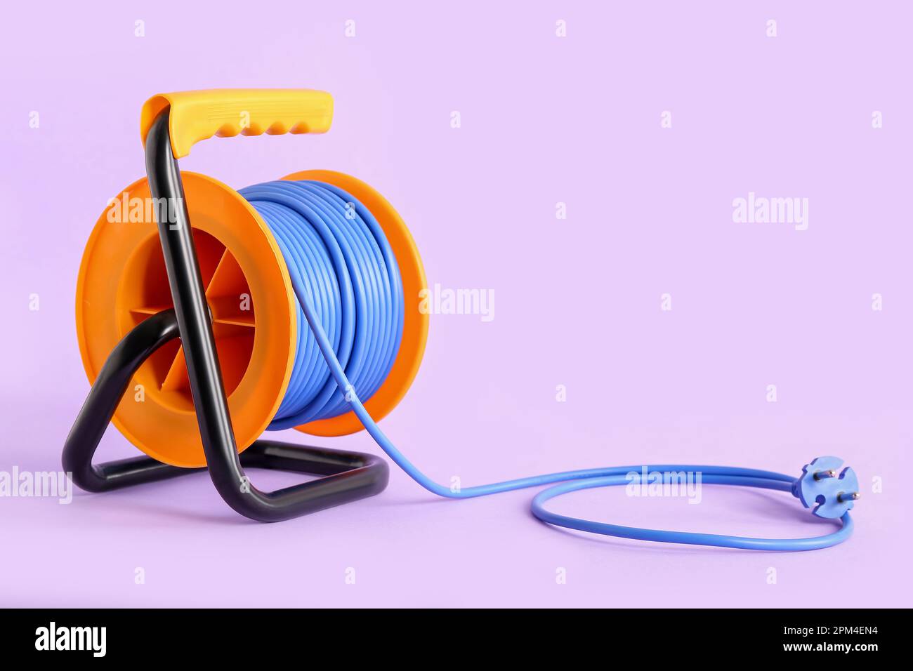 Extension electric cable reel on lilac background Stock Photo - Alamy
