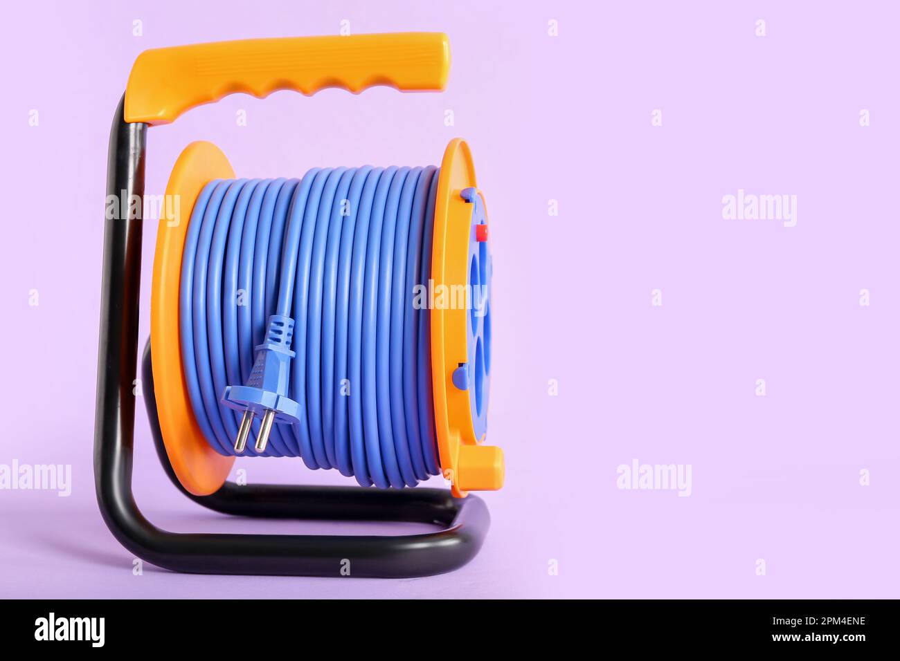 Extension electric cable reel on lilac background Stock Photo - Alamy