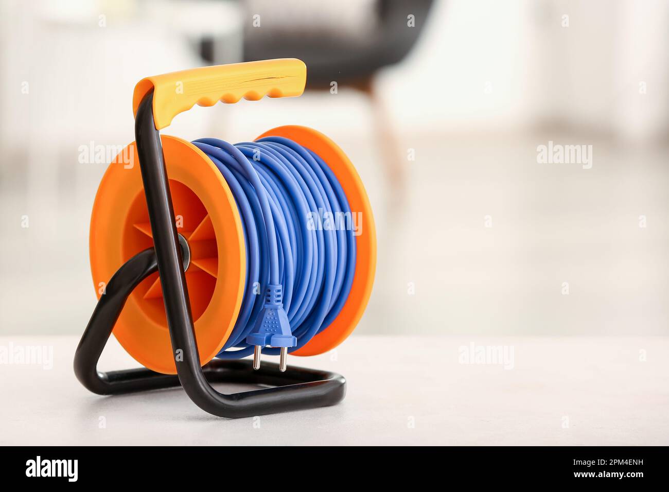 Extension electric cable reel on table Stock Photo - Alamy