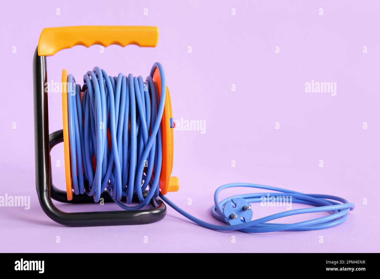 Extension electric cable reel on lilac background Stock Photo - Alamy