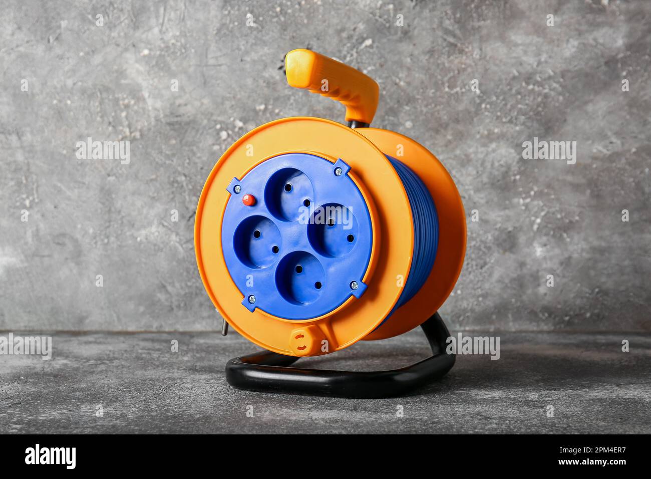Extension electric cable reel on grunge background Stock Photo - Alamy