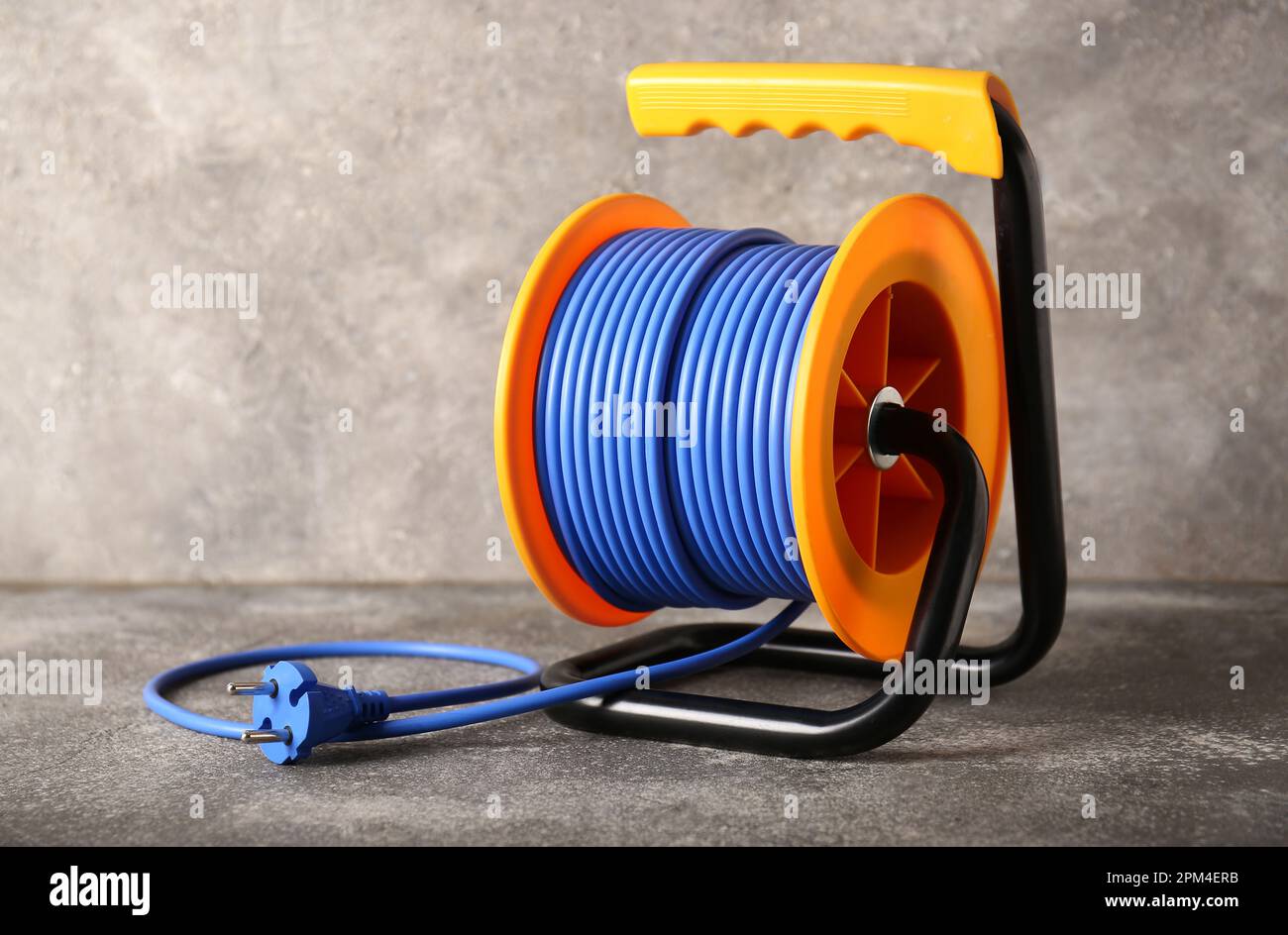 Extension electric cable reel on grunge background Stock Photo - Alamy