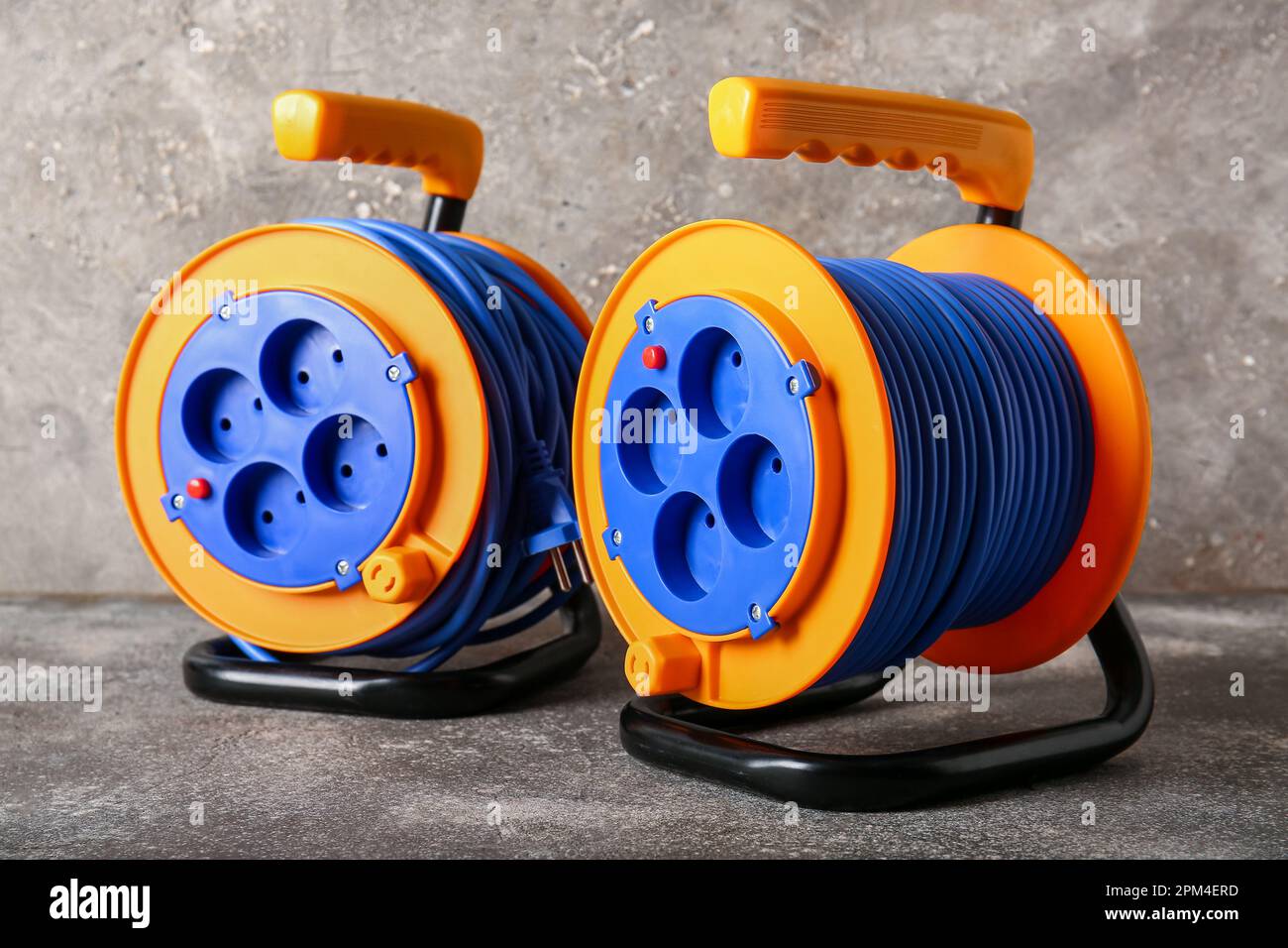 Extension electric cable reels on grunge background Stock Photo - Alamy