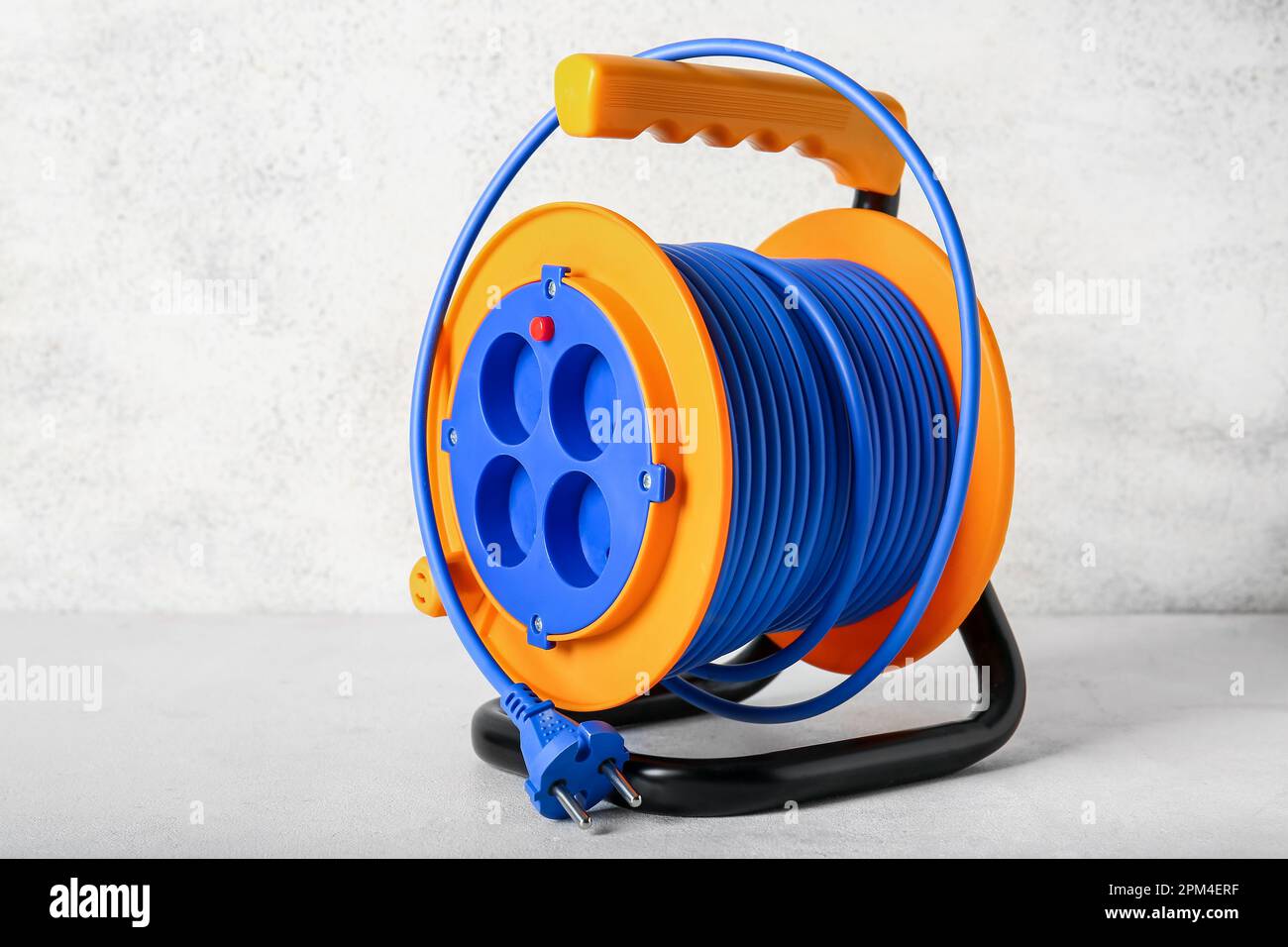 Extension electric cable reel on light background Stock Photo - Alamy