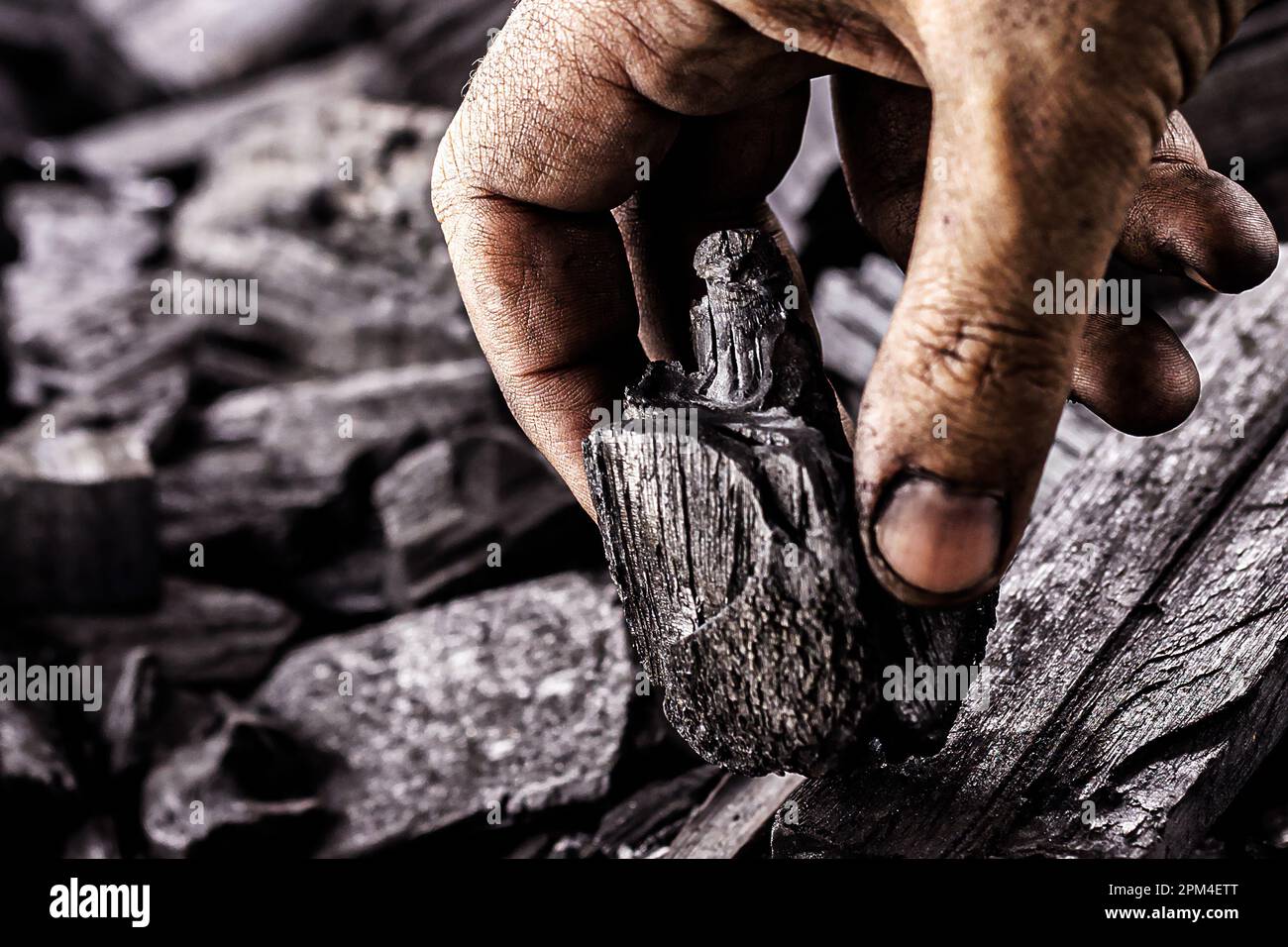 hand holding piece of charcoal, with background. Dirty coal emitter ...