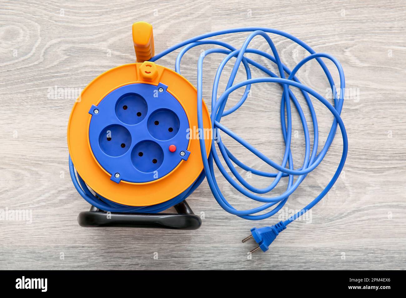 Extension electric cable reel on light wooden background Stock Photo ...