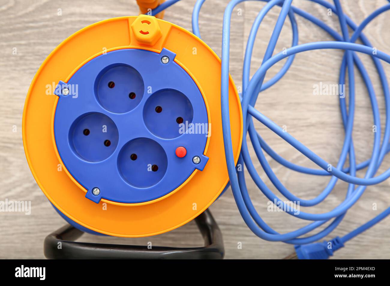 Extension electric cable reel on light wooden background, closeup Stock ...