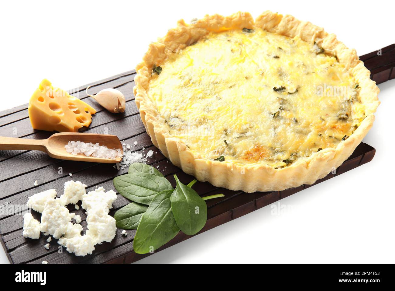 Board with delicious quiche, cheese and spinach leaves isolated on ...