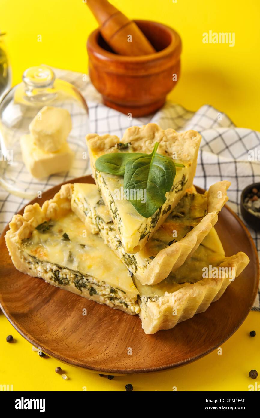 Board with pieces of delicious quiche on yellow background Stock Photo ...