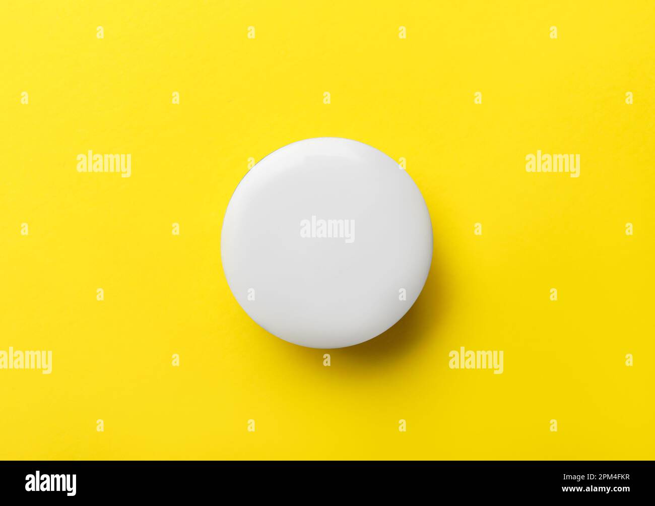 Blank white badge on yellow background Stock Photo - Alamy