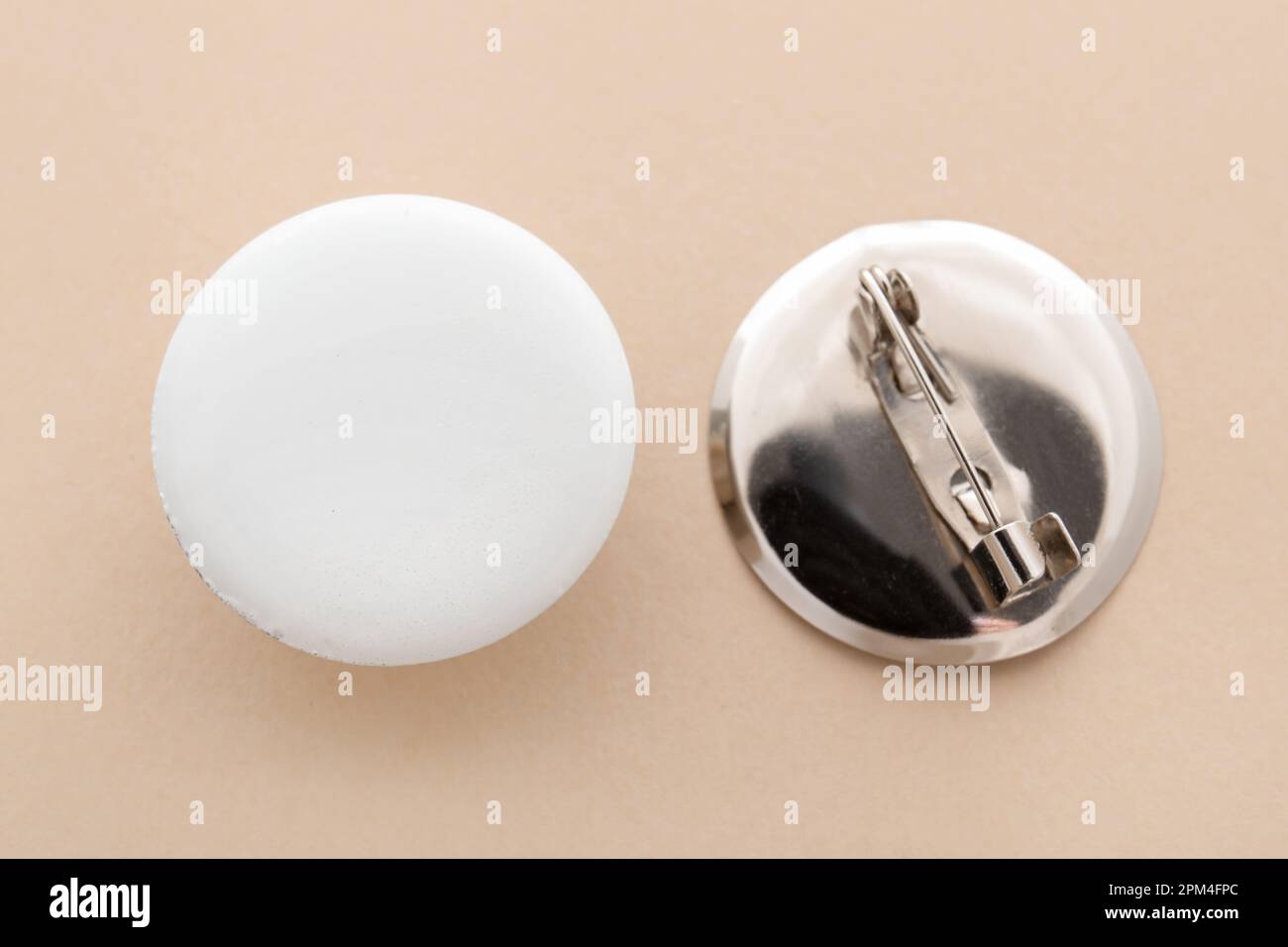 Blank white badges on beige background Stock Photo - Alamy