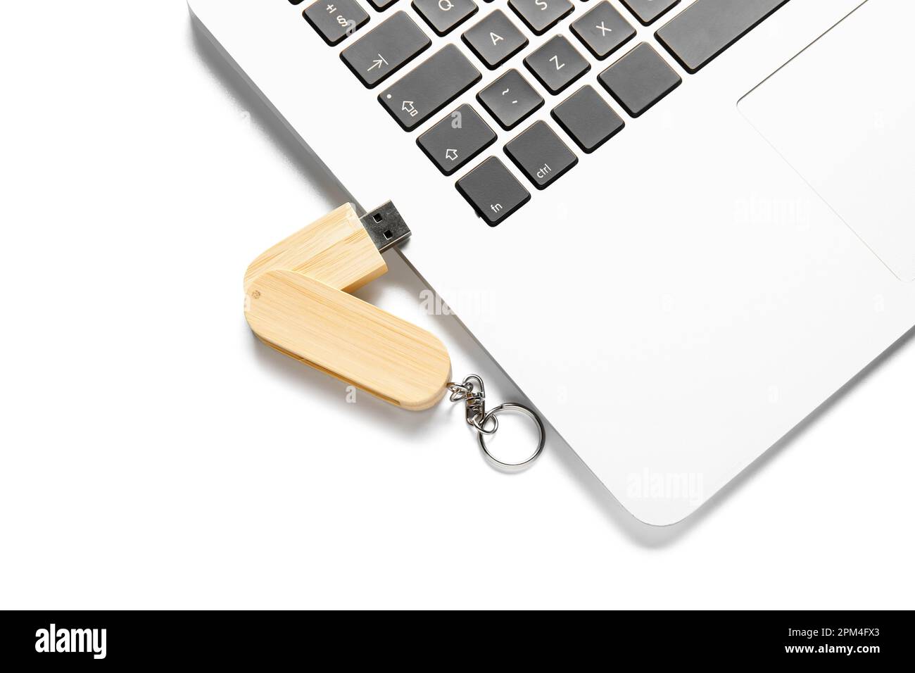 Modern laptop with wooden USB flash drive isolated on white background ...