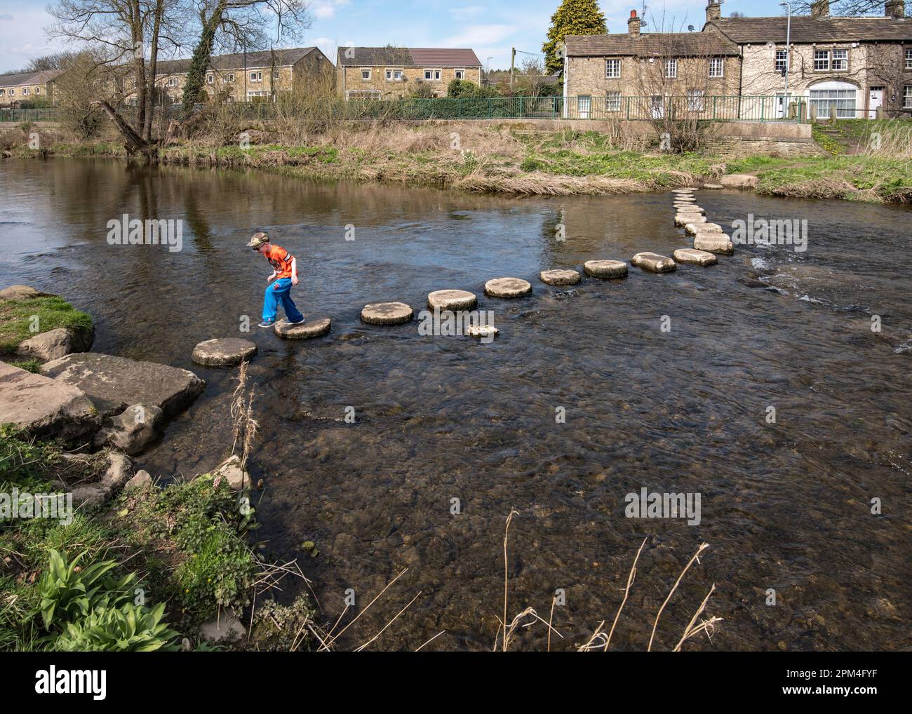 Youngster having fun whilst confidently hopping across the stepping ...