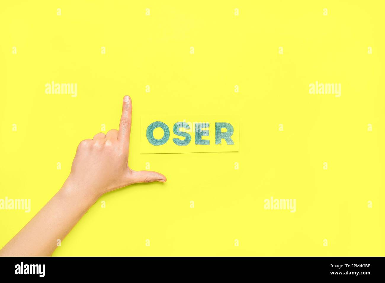 Woman showing loser gesture on yellow background Stock Photo - Alamy