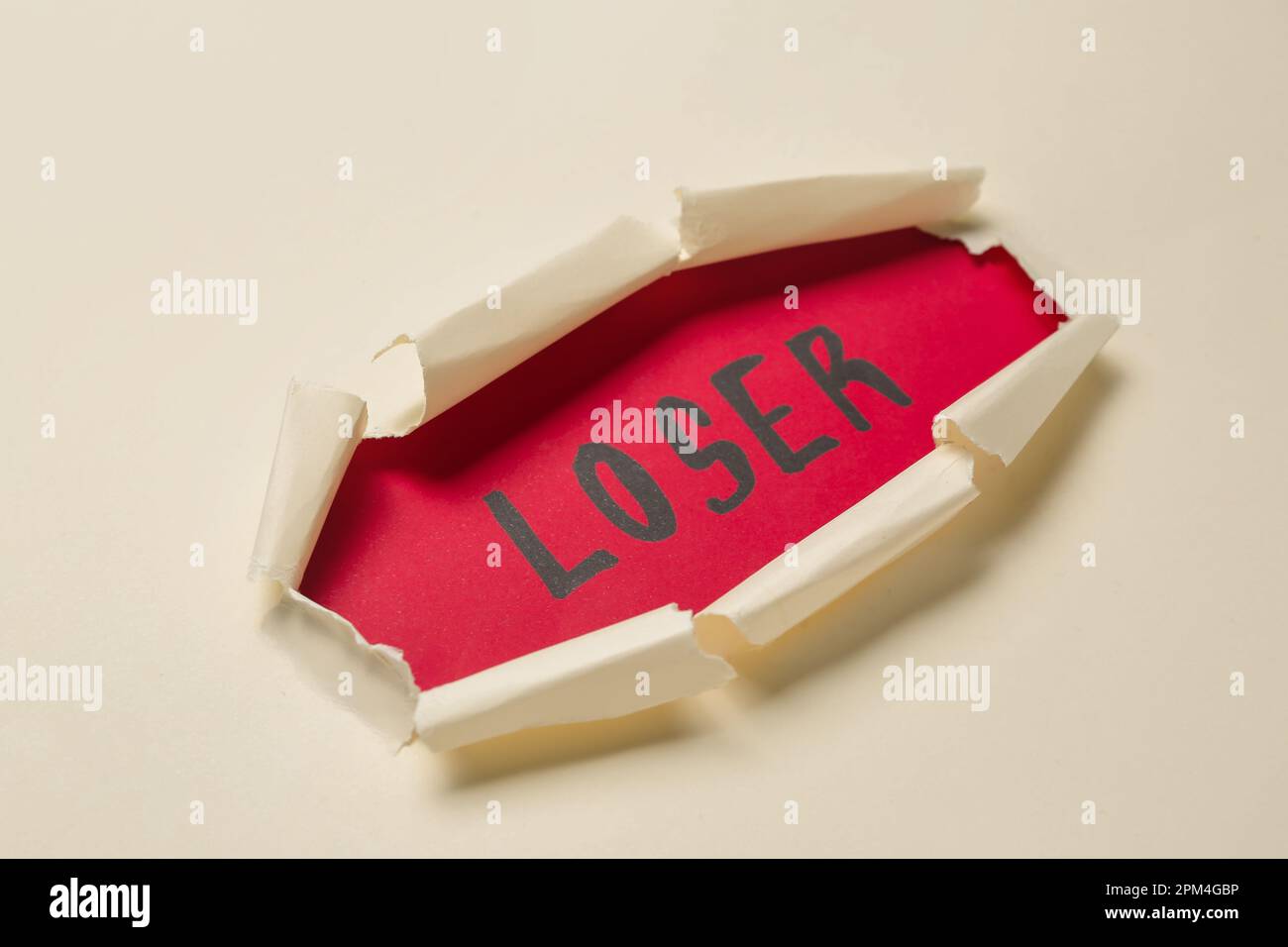 Word LOSER visible through hole in white paper, closeup Stock Photo - Alamy