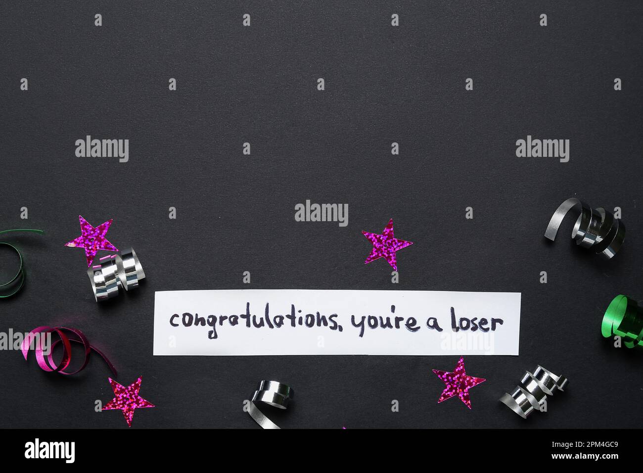Paper with text CONGRATULATIONS YOU'RE A LOSER, stars and serpentine on ...