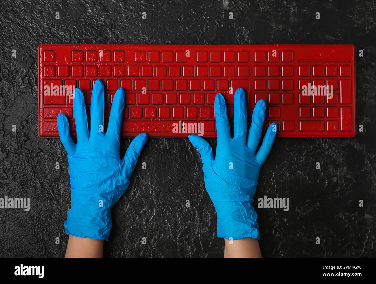 Woman in rubber gloves with computer keyboard on dark background Stock ...
