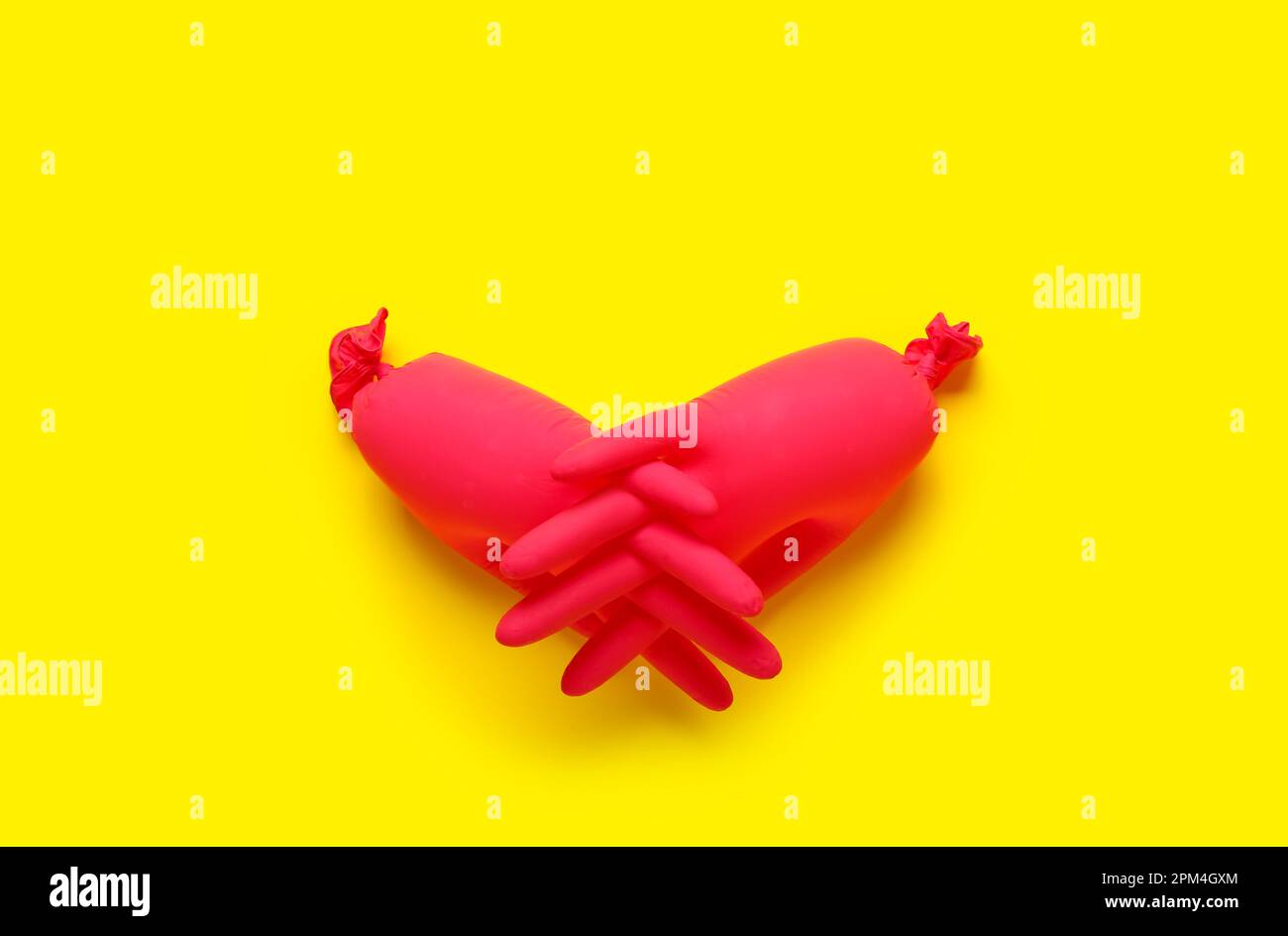 Inflated medical gloves on yellow background Stock Photo - Alamy