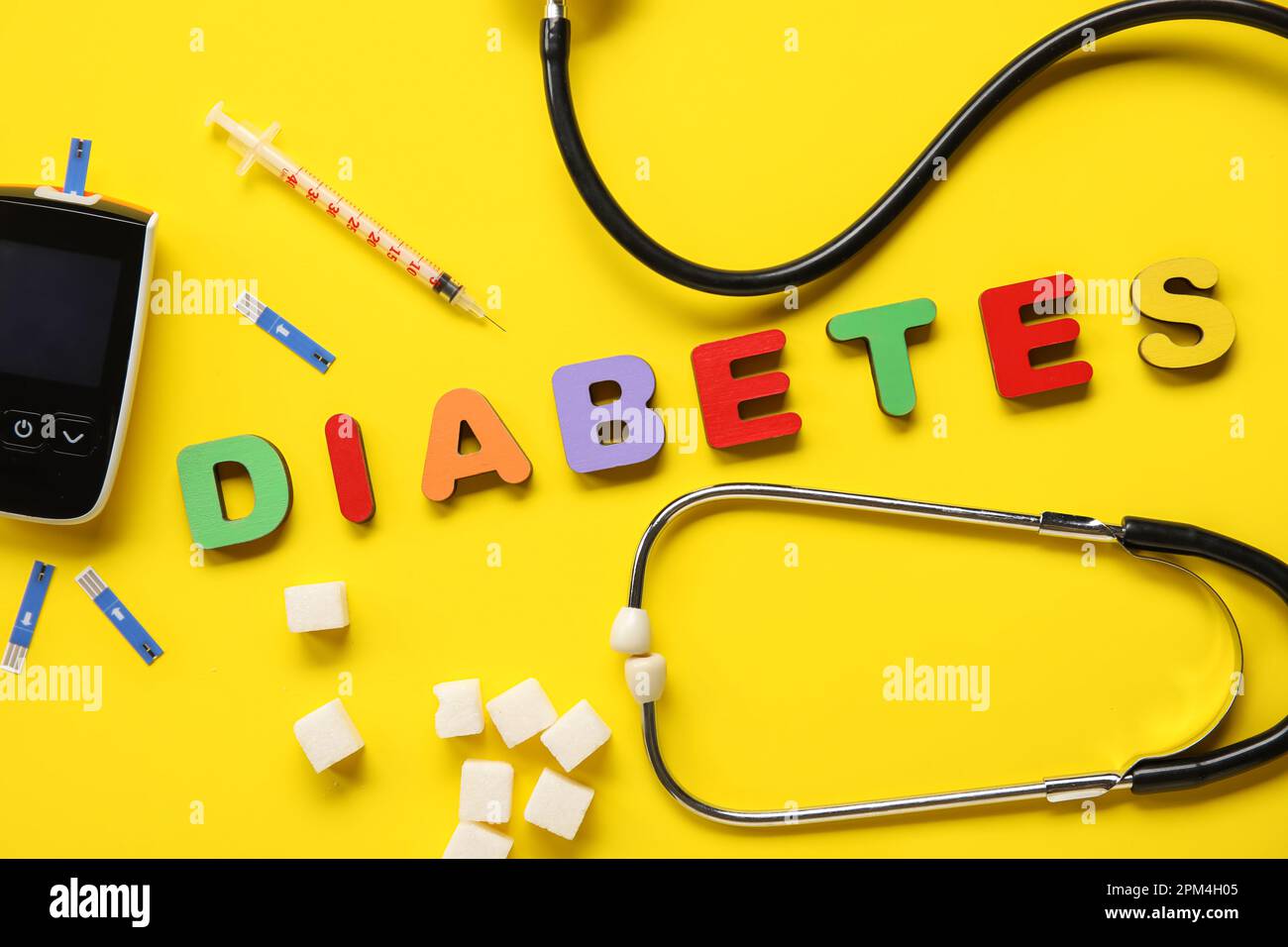 Word DIABETES with sugar, glucometer and syringe on yellow background ...