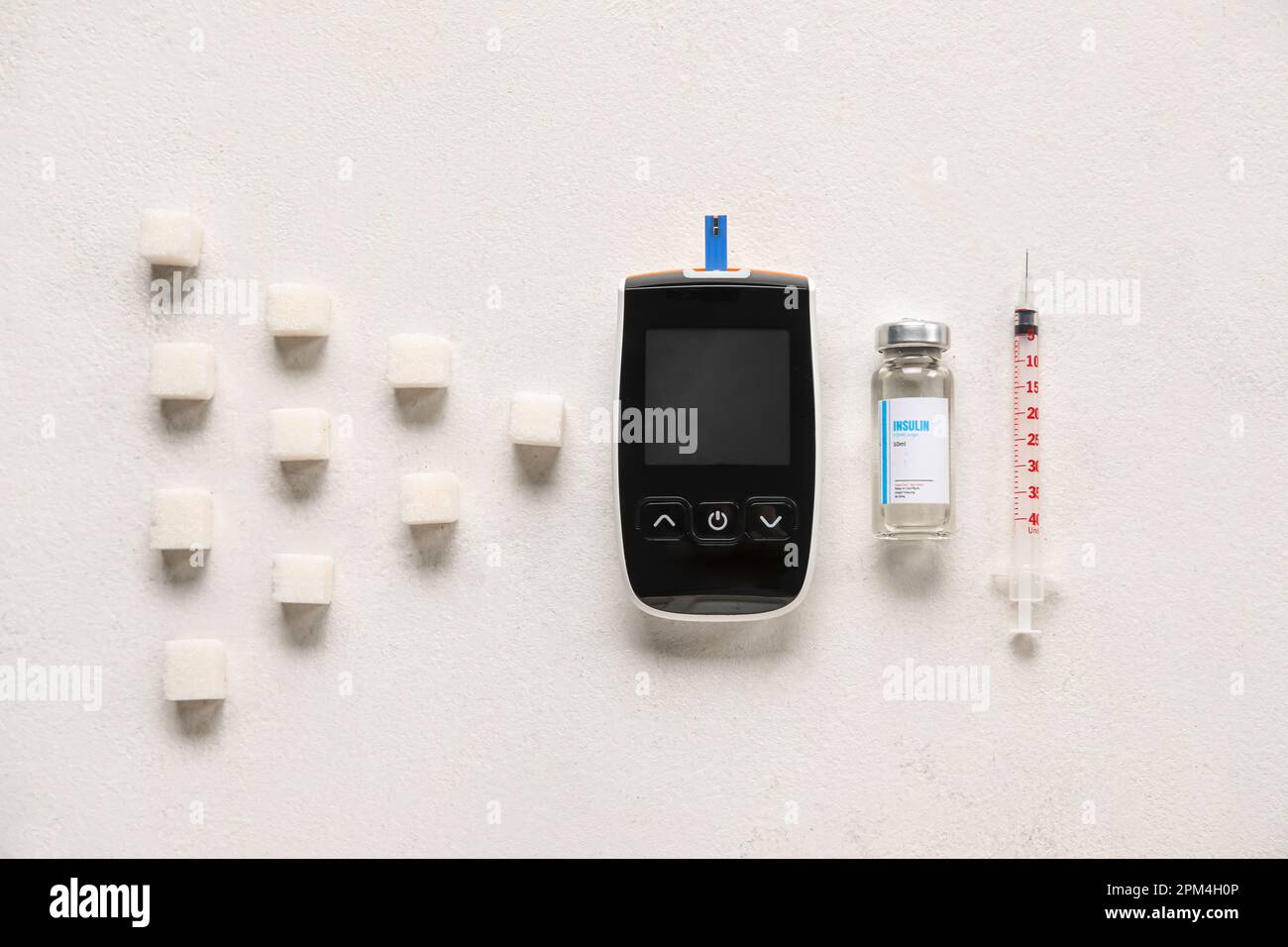 Glucometer with insulin, syringe and sugar on white background ...