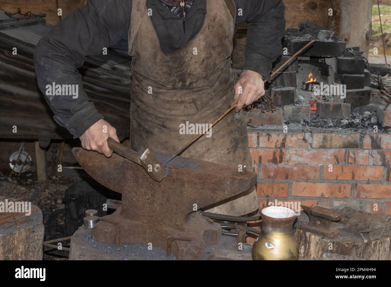 blacksmith works in the forge with a hammer Stock Photo - Alamy