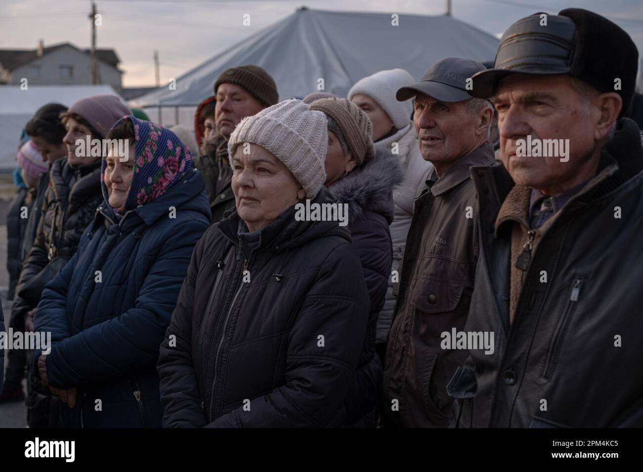 People wait in a queue for the distribution of humanitarian aid in the ...