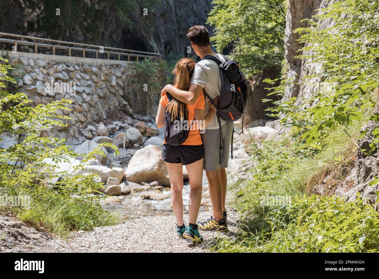 Two young hikers with backpacks, a couple in love exploring nature ...