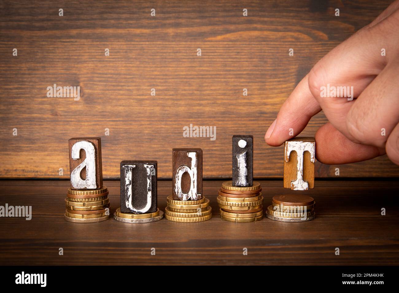 AUDIT Concept. Alphabet blocks and change on wood texture background ...
