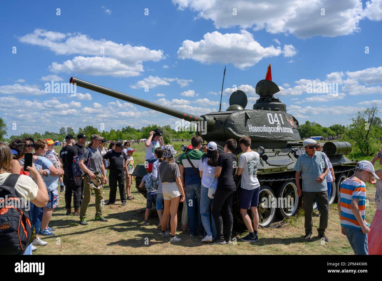 Tourists around a World War II battle tank in a forest clearing. The ...